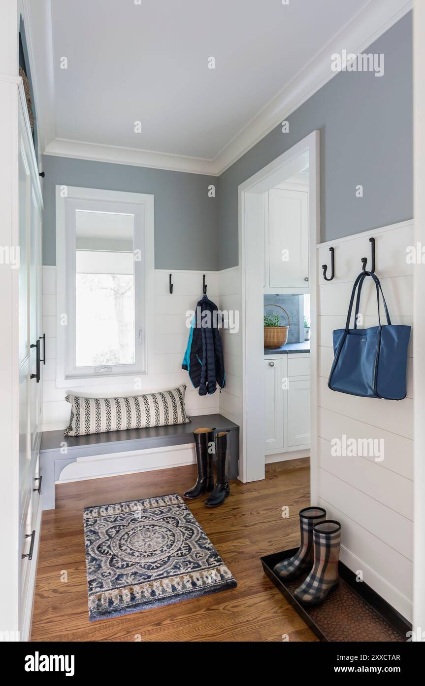 Mudroom with wainscoting and built-in bench next to kitchen Stock Photo ...