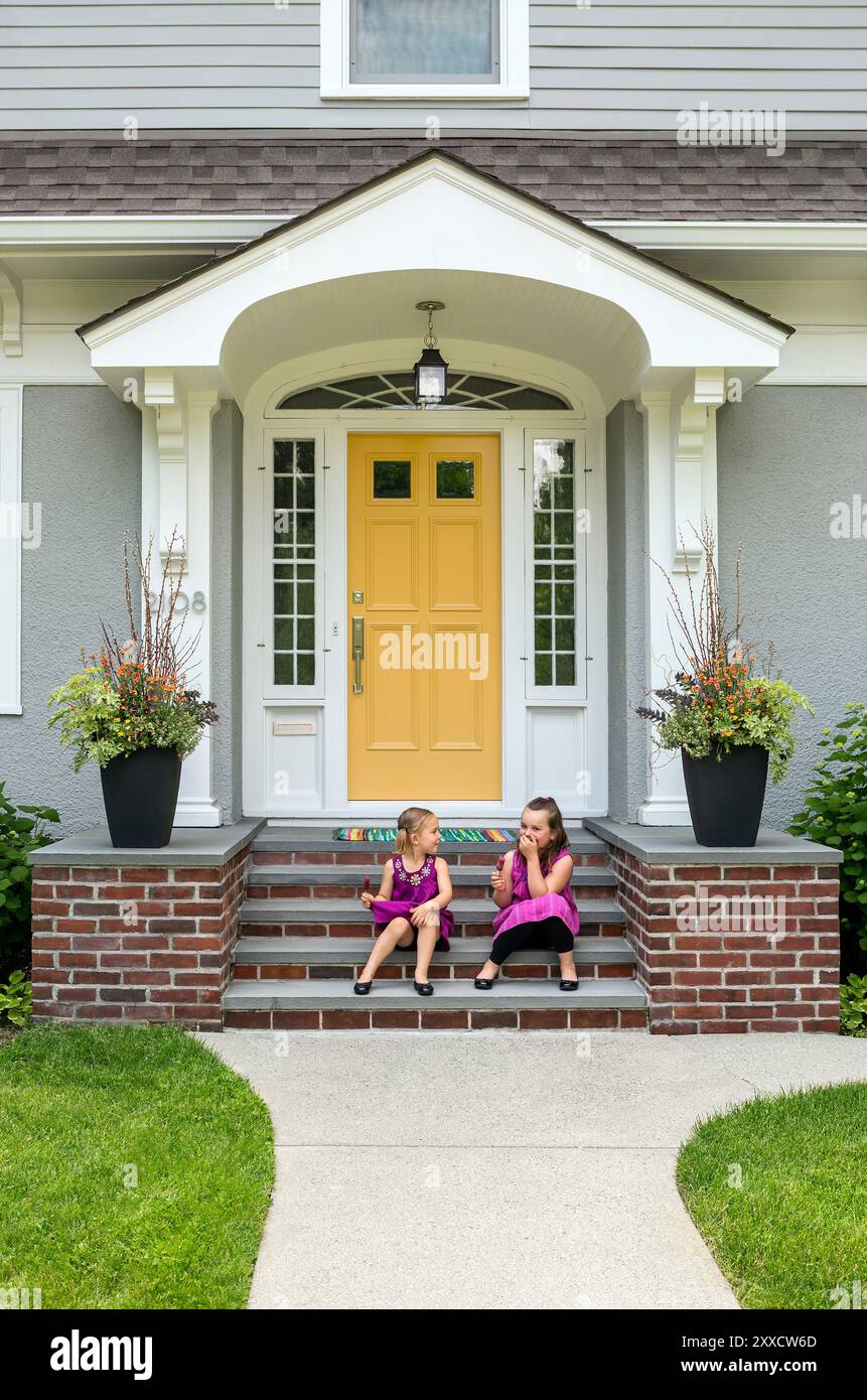 Two youngs girls having fun sitting on front steps of their house Stock ...