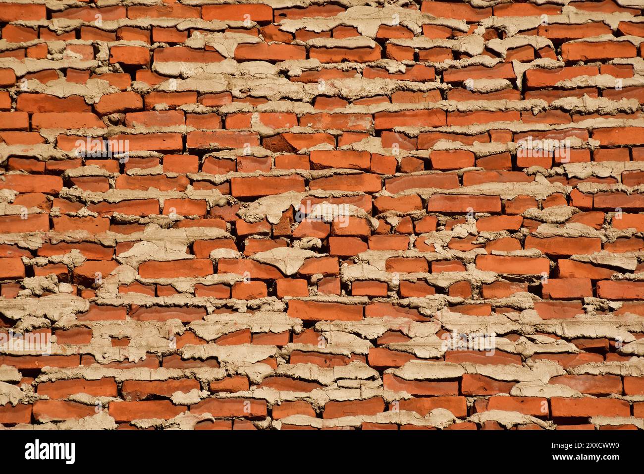 Backside of a brick wall. Uneven brick layout with mortar oozing out ...