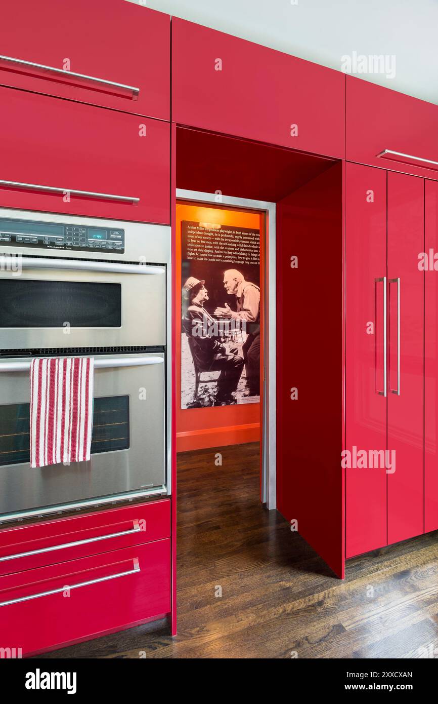 Shiny red Ikea cabinets in kitchen with wall ovens Stock Photo - Alamy