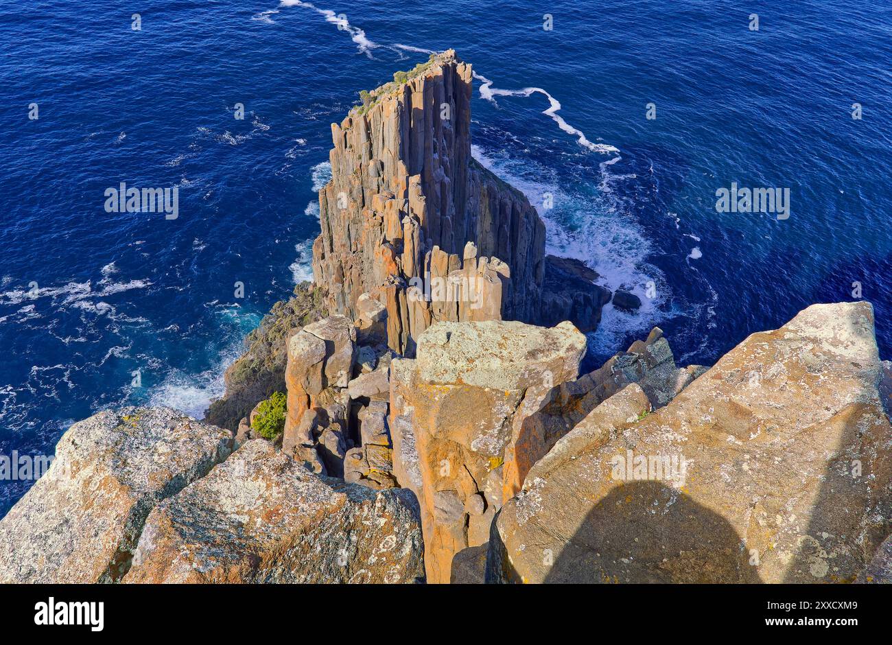 Wide view of dolerite pillars and blue ocean in sun at Cape Raoul ...