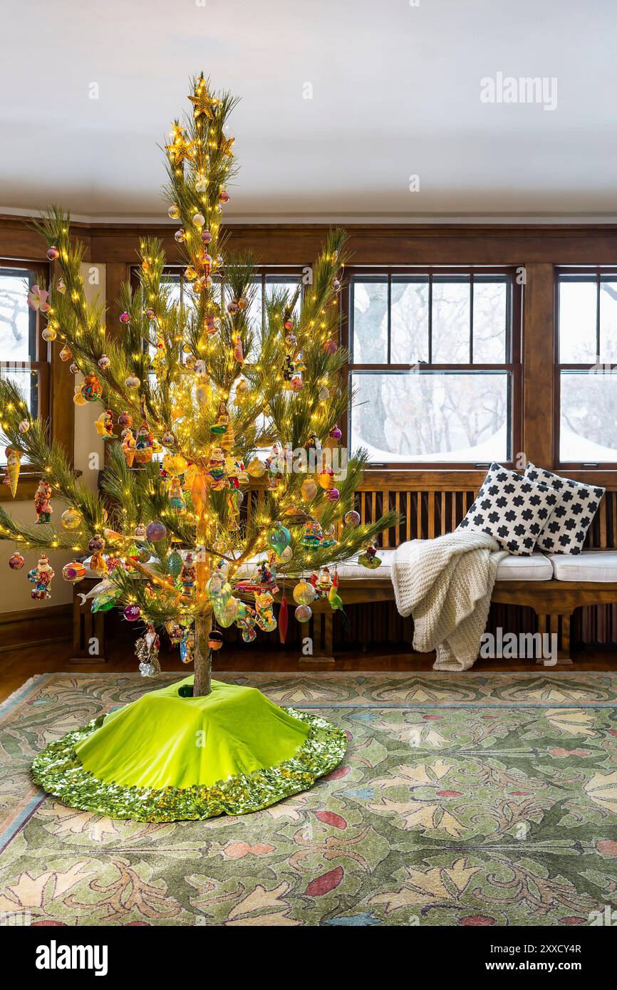 Christmas tree set up in room with built-in bench beneath windows with ...