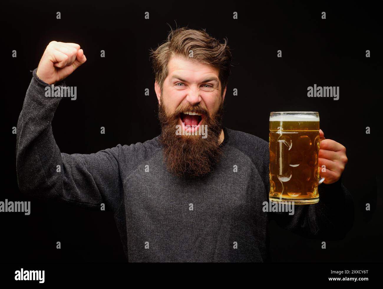 Happy bearded man with beer mug celebrating victory with raised hand ...