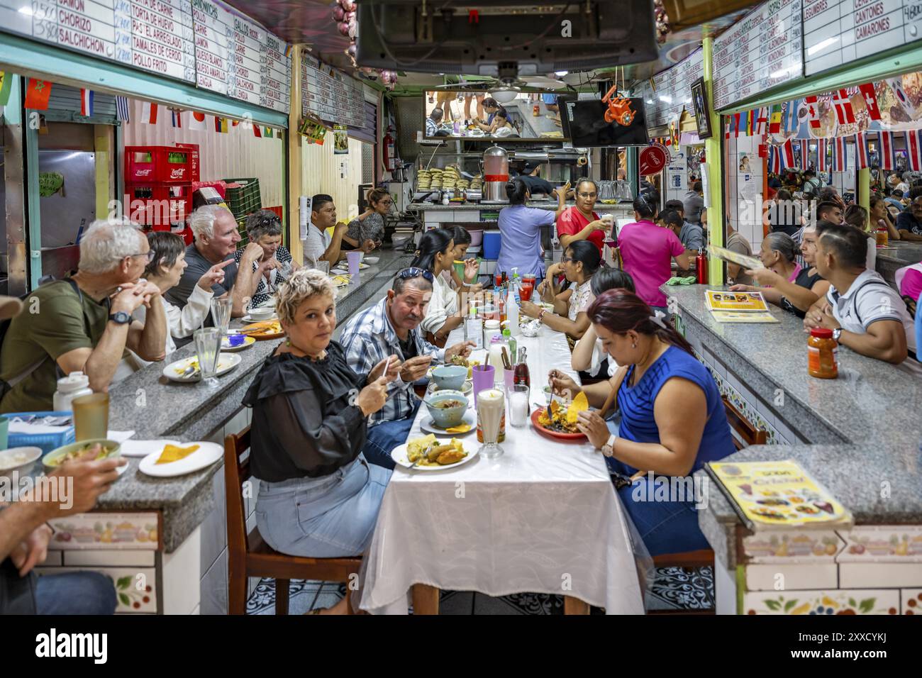 Visitors sitting at a table at a food stall, Mercado Central de San ...