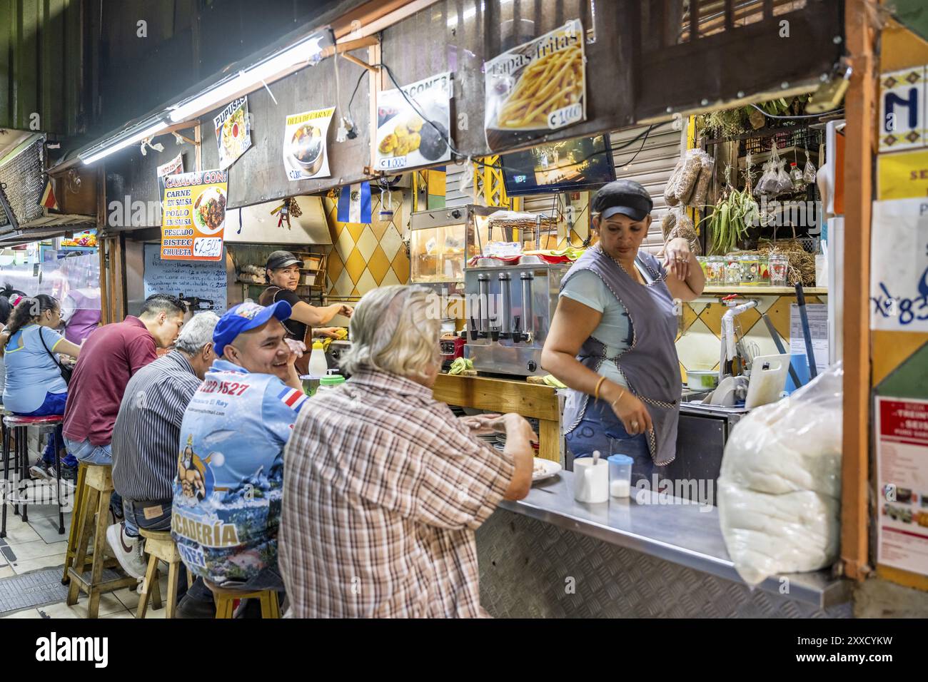 Visitors sitting at a food stall at the counter, Mercado Central de San ...