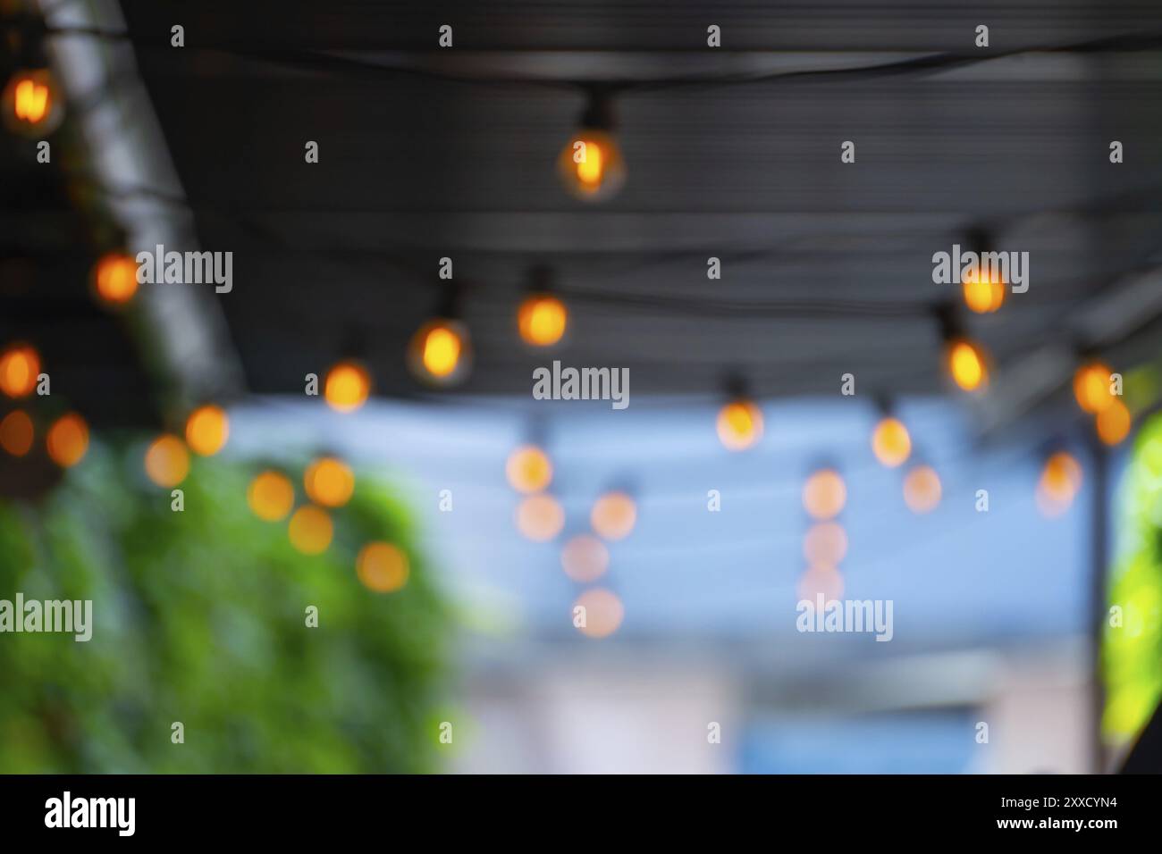Out of focus image of decorative light bulbs hanging from the roof ...