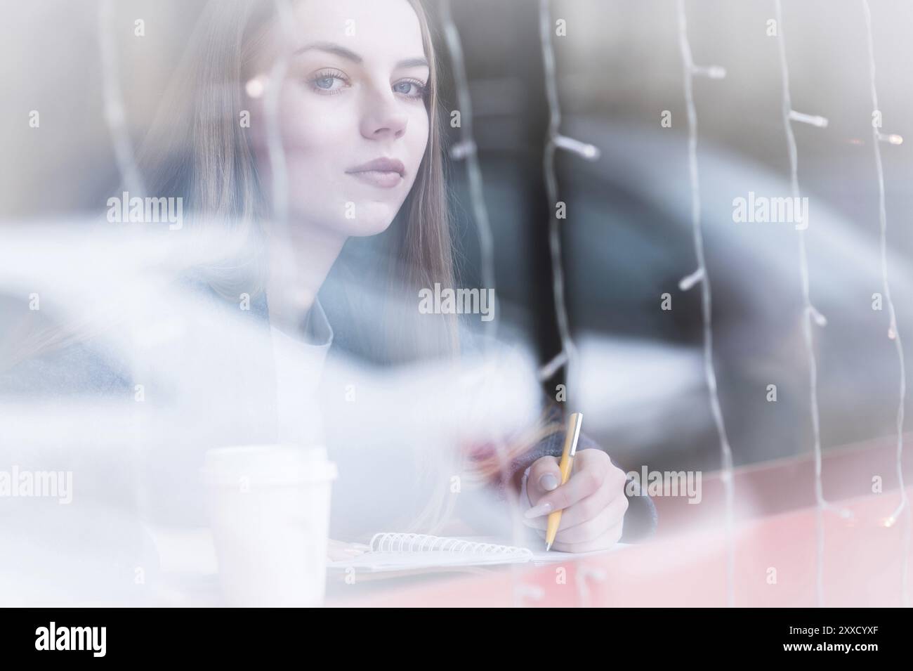 Portrait of an attractive young journalist girl with pen and notepad in ...
