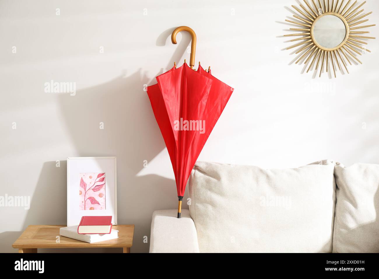 Red umbrella drying on sofa at home Stock Photo - Alamy