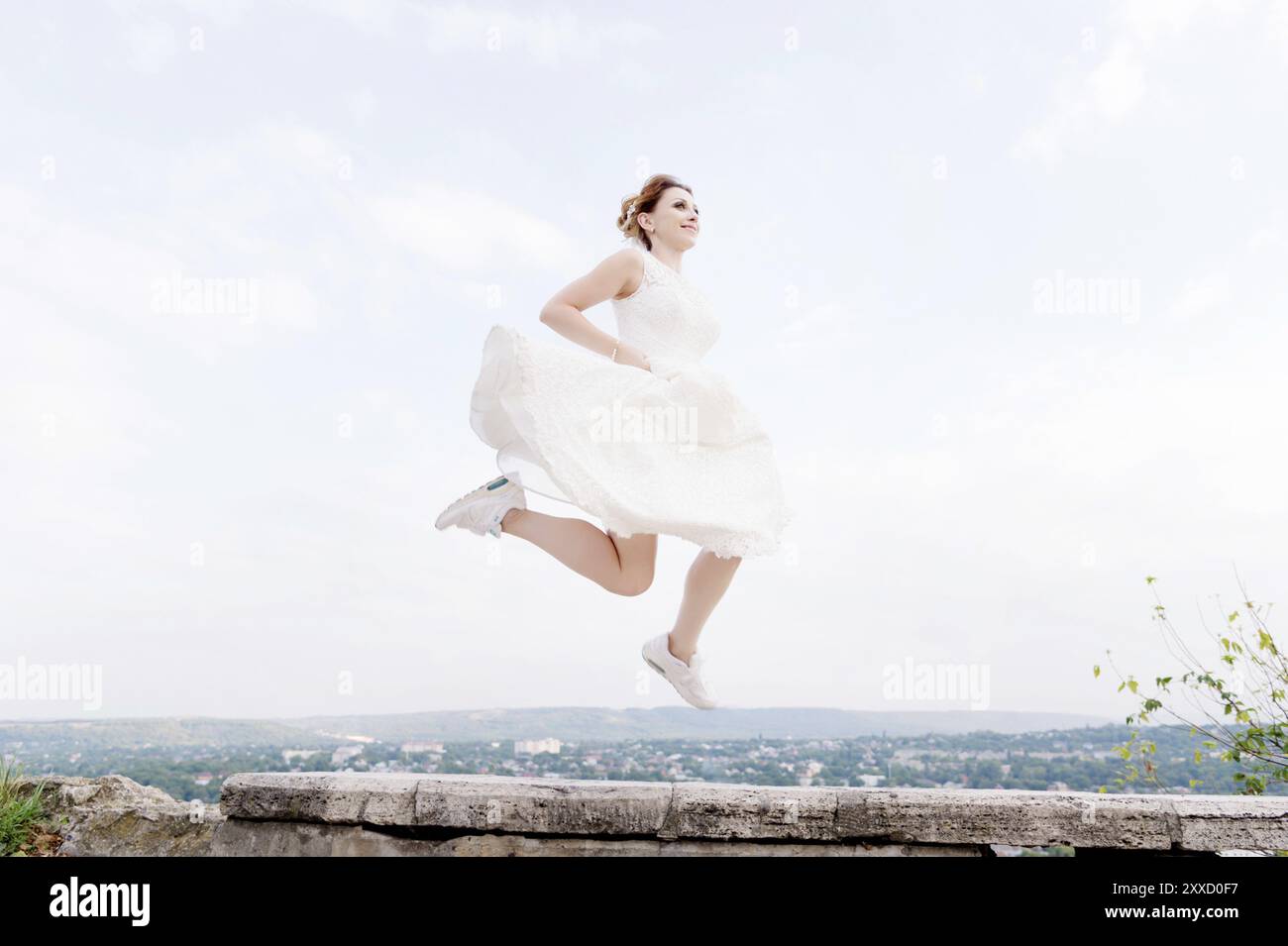 The crazy bride jumps and hangs in the sky against the backdrop of the ...