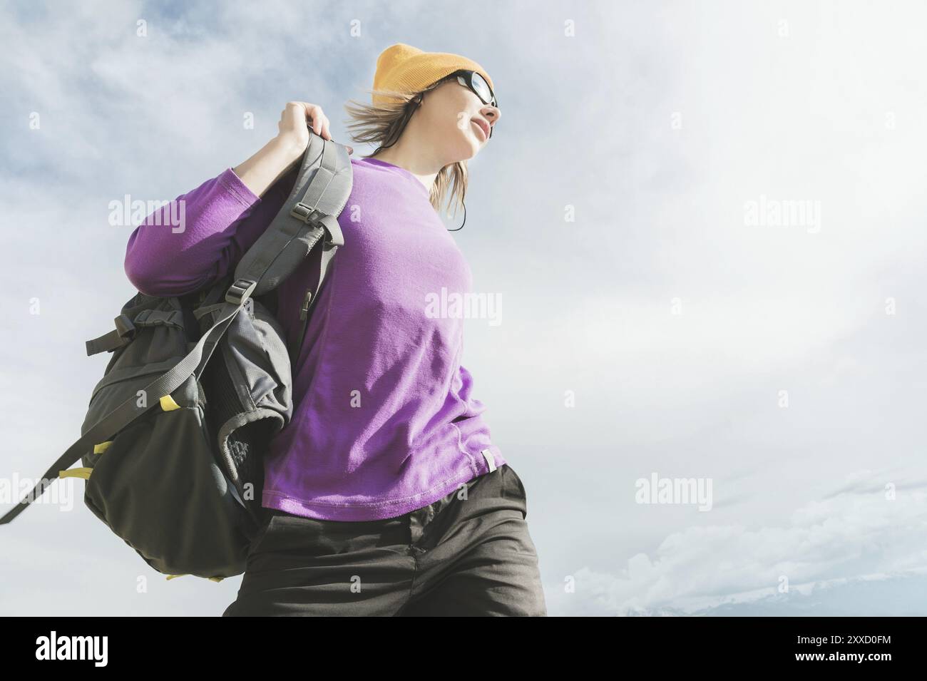 The tourist's girl in sunglasses puts on a backpack on the background ...