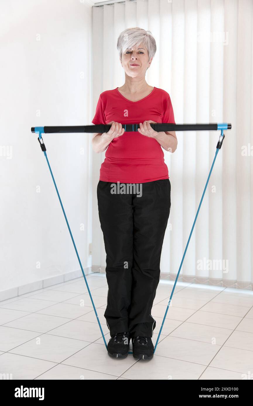 Woman, 50+, exercises with a training stick Stock Photo - Alamy