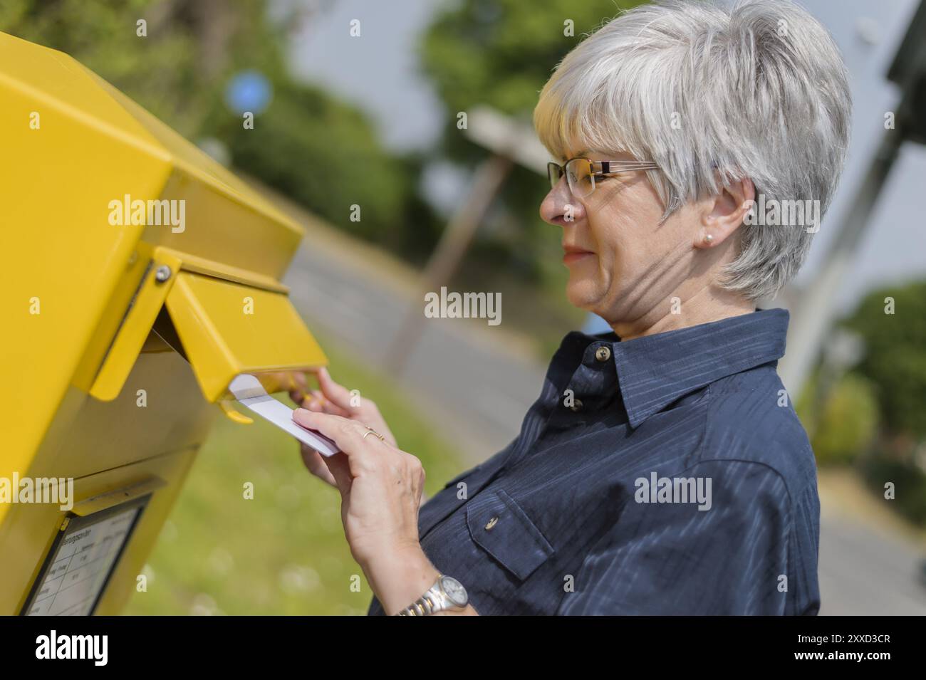 A senior citizen puts a letter in the letterbox slot Stock Photo - Alamy