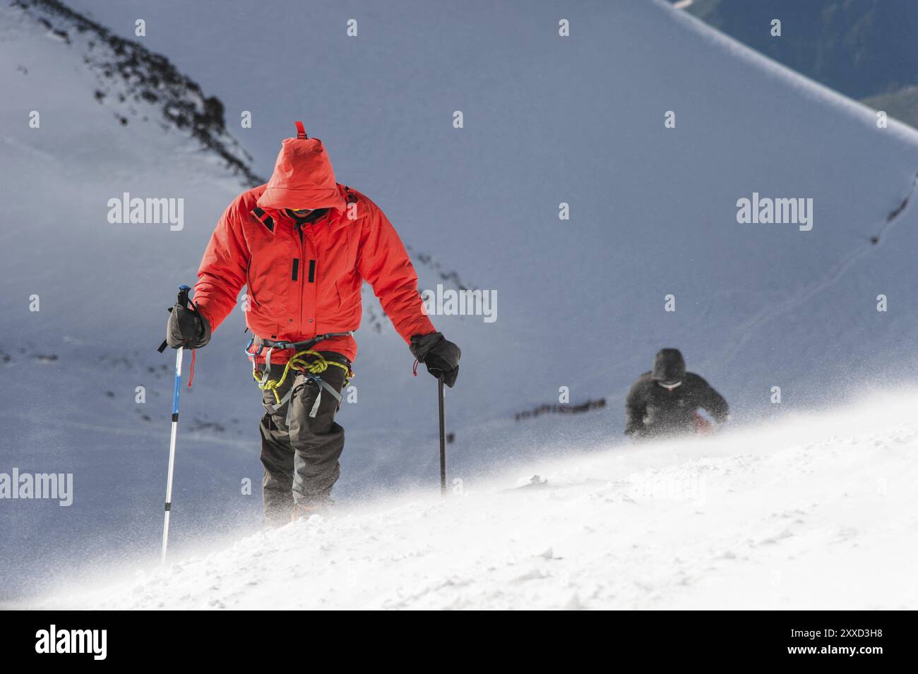 The climber climbs the snow-covered summit. The concept of overcoming ...