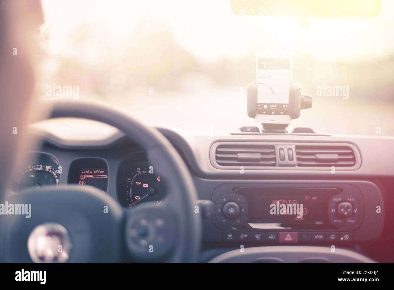 Car dashboard with smartphone used as navigation device, bright and ...