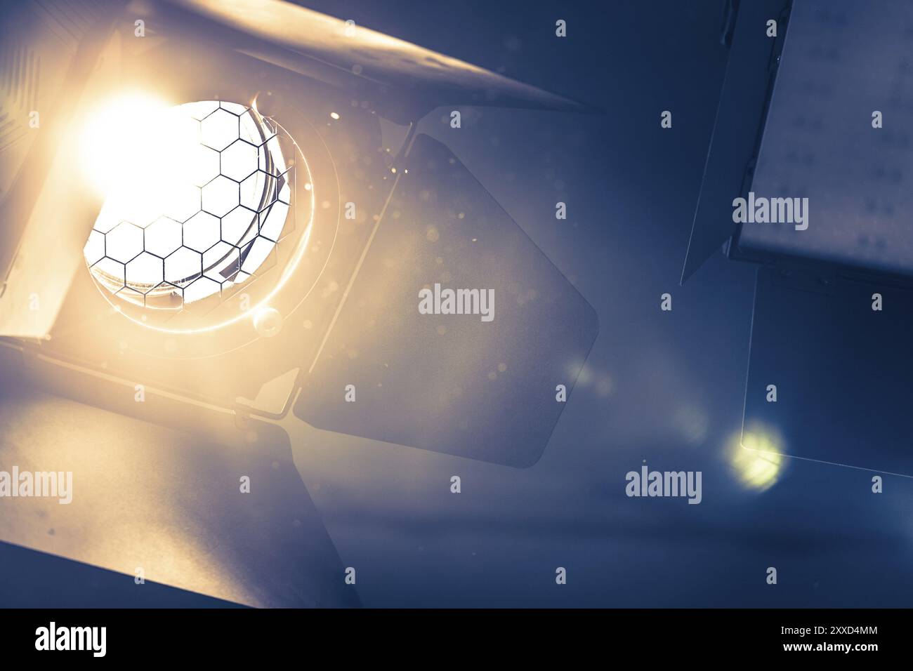 Professional orange studio spotlight hanging on the ceiling. Lighted ...