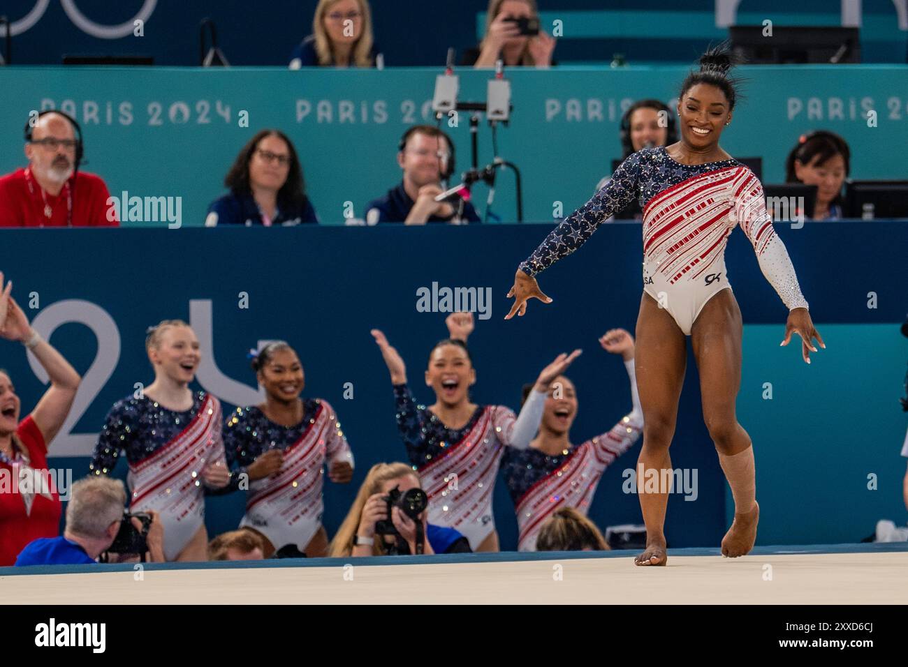 Simone Biles USA) competes on the floor exercise as her teammates cheer ...