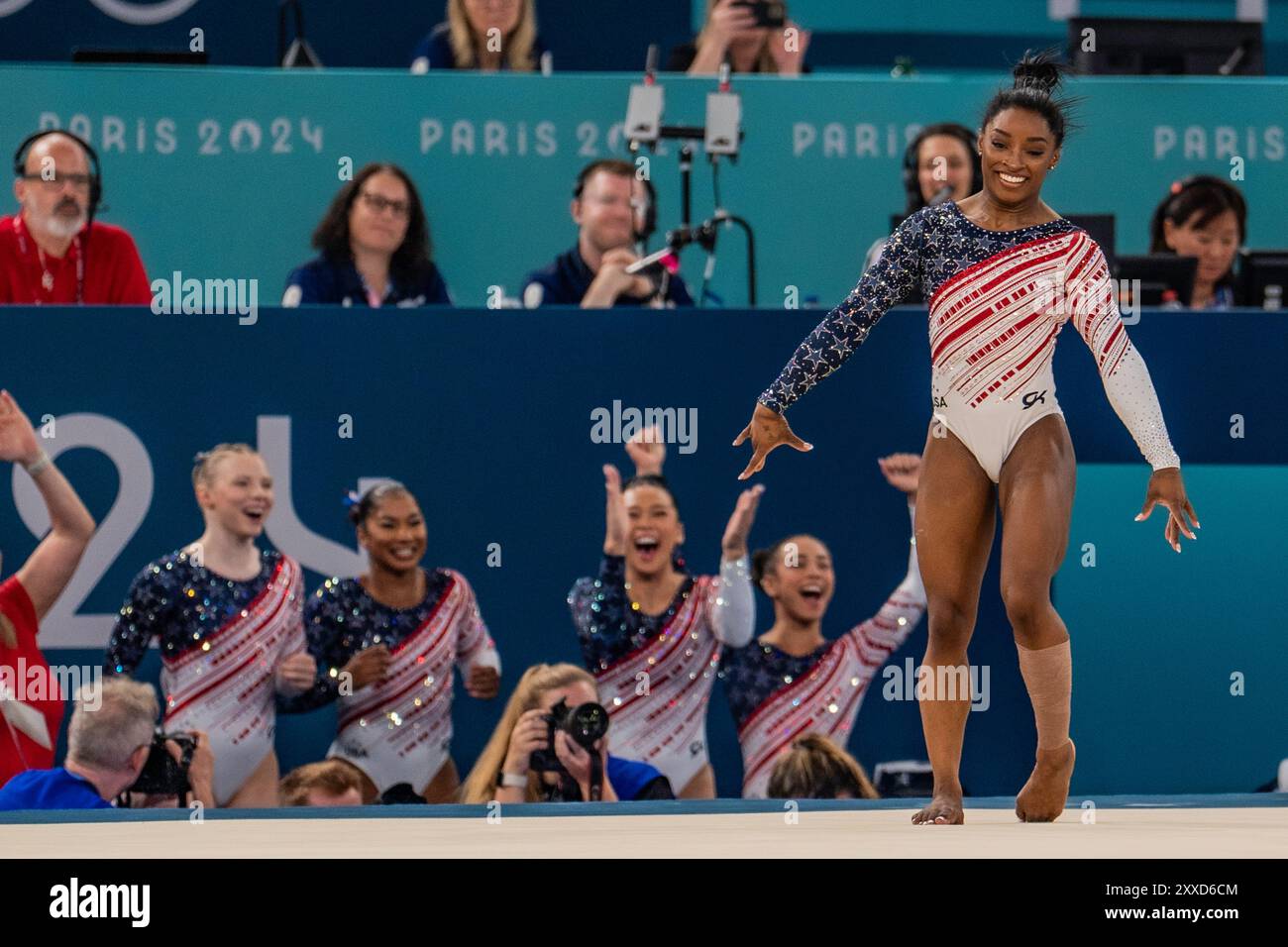 Simone Biles USA) competes on the floor exercise as her teammates cheer ...