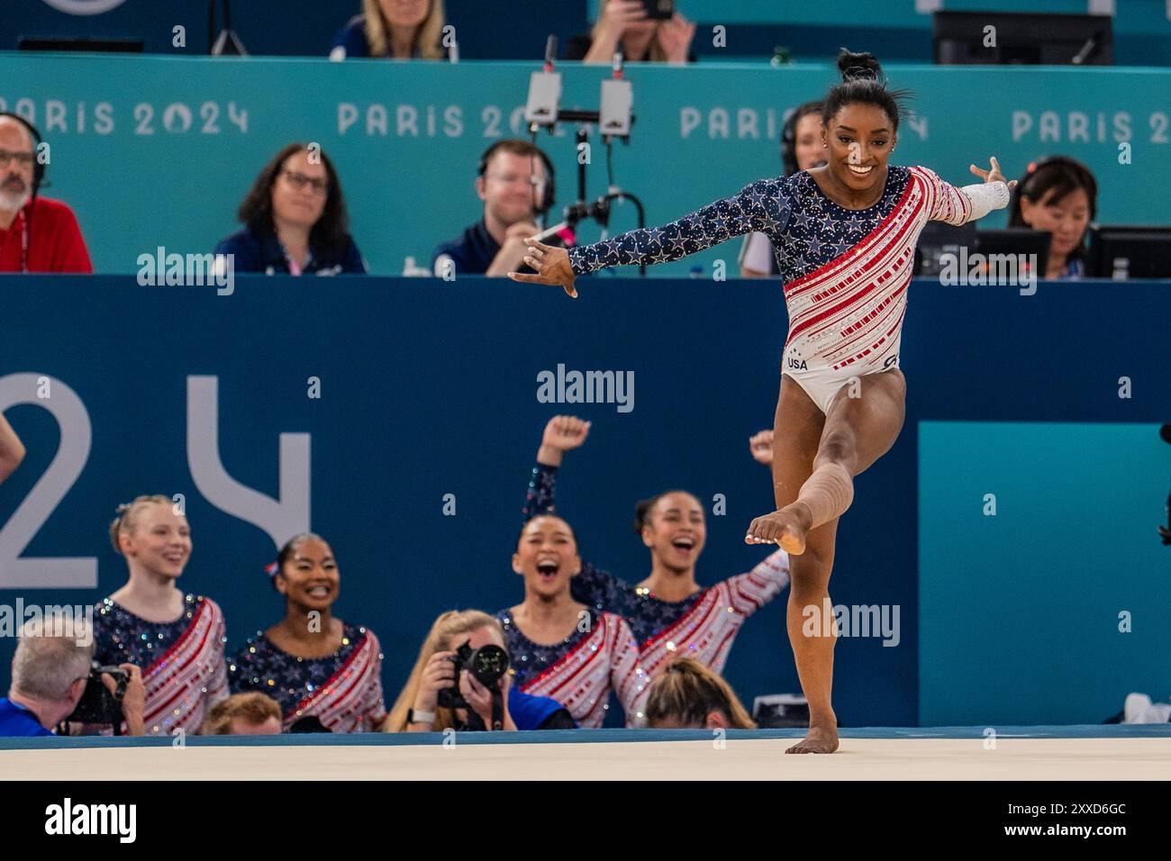 Simone Biles USA) competes on the floor exercise as her teammates cheer ...