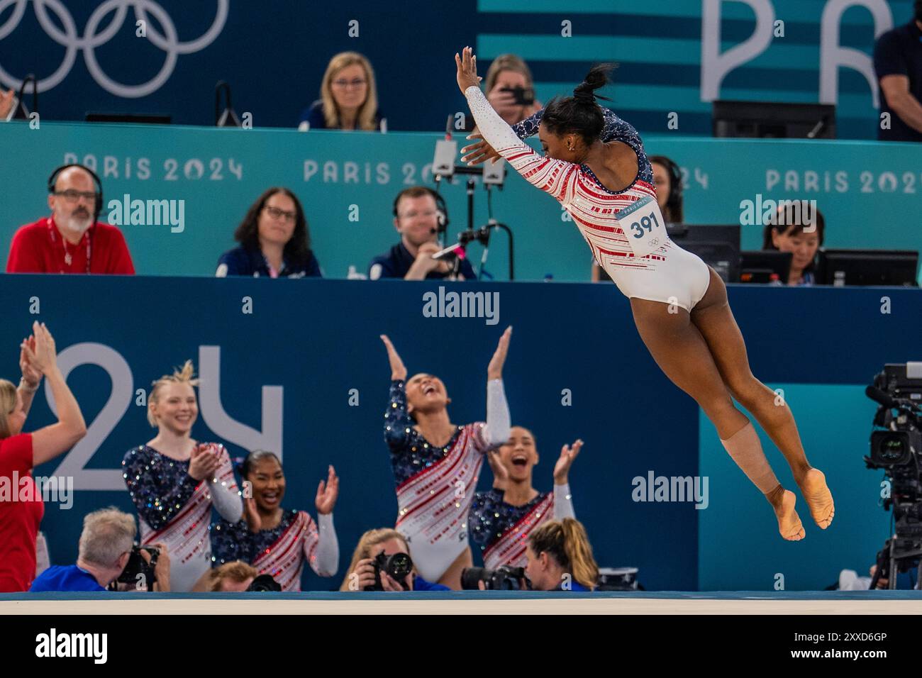 Simone Biles USA) competes on the floor exercise as her teammates cheer ...