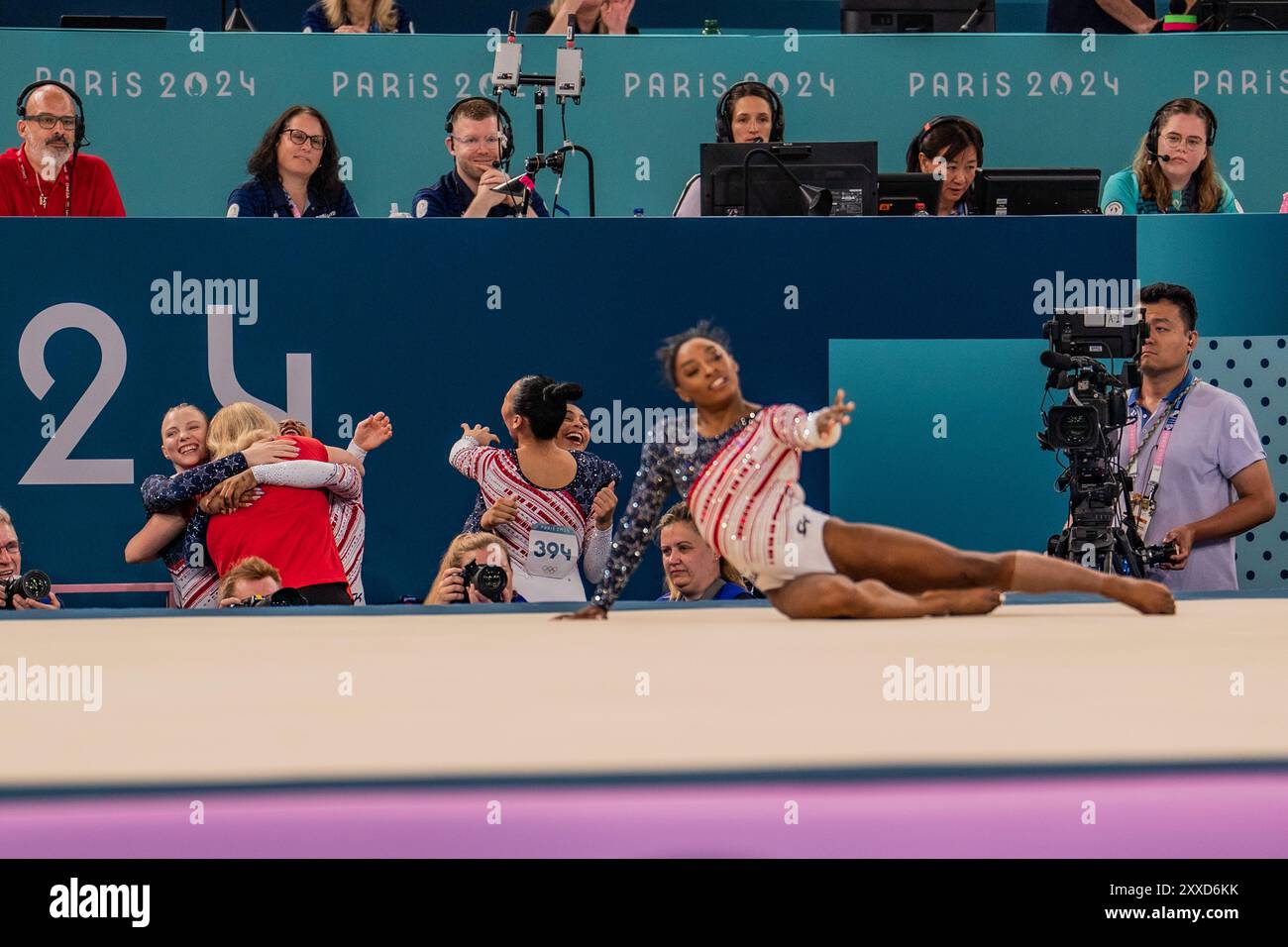 Simone Biles USA) competes on the floor exercise as her teammates cheer ...