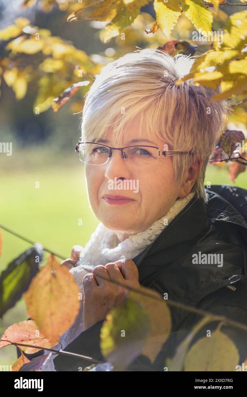 Portrait of a friendly senior citizen with short grey hair and glasses ...