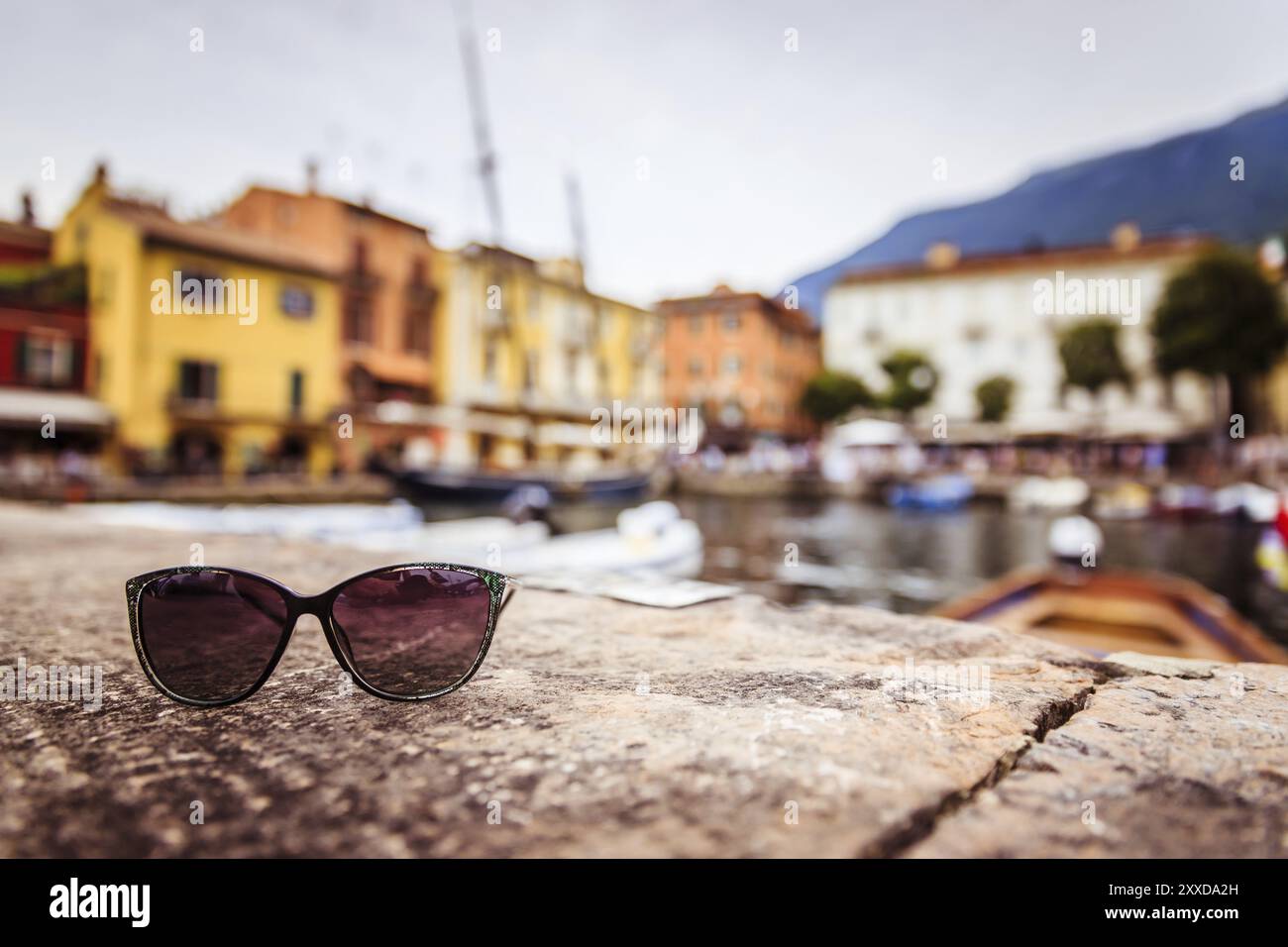 Italian harbour scene: Sunglasses on the stony ground Stock Photo - Alamy