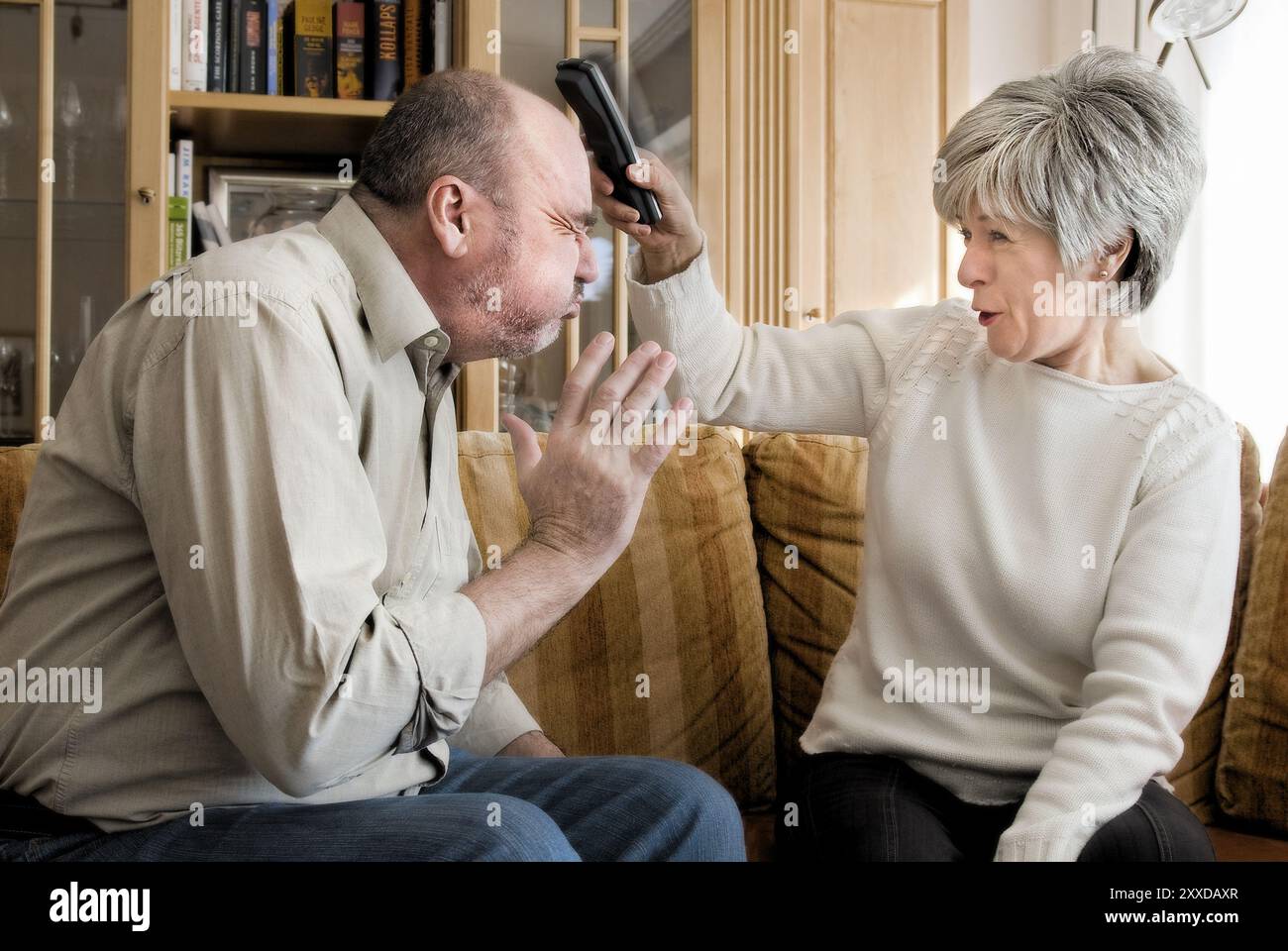 Married couple fight over the TV remote control Stock Photo - Alamy