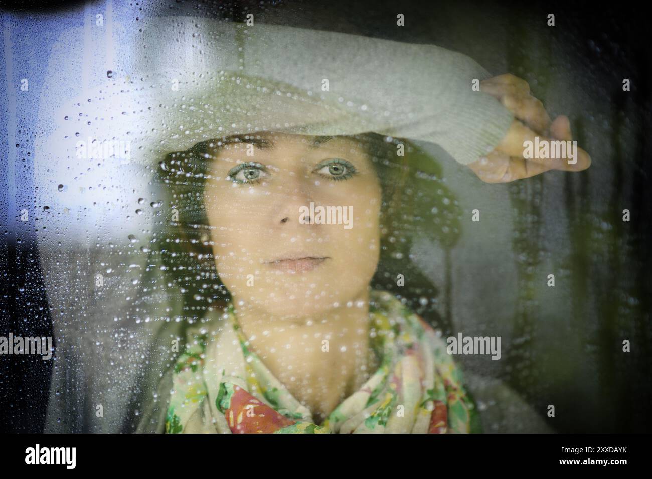 Young woman looks through the window in rainy weather Stock Photo - Alamy