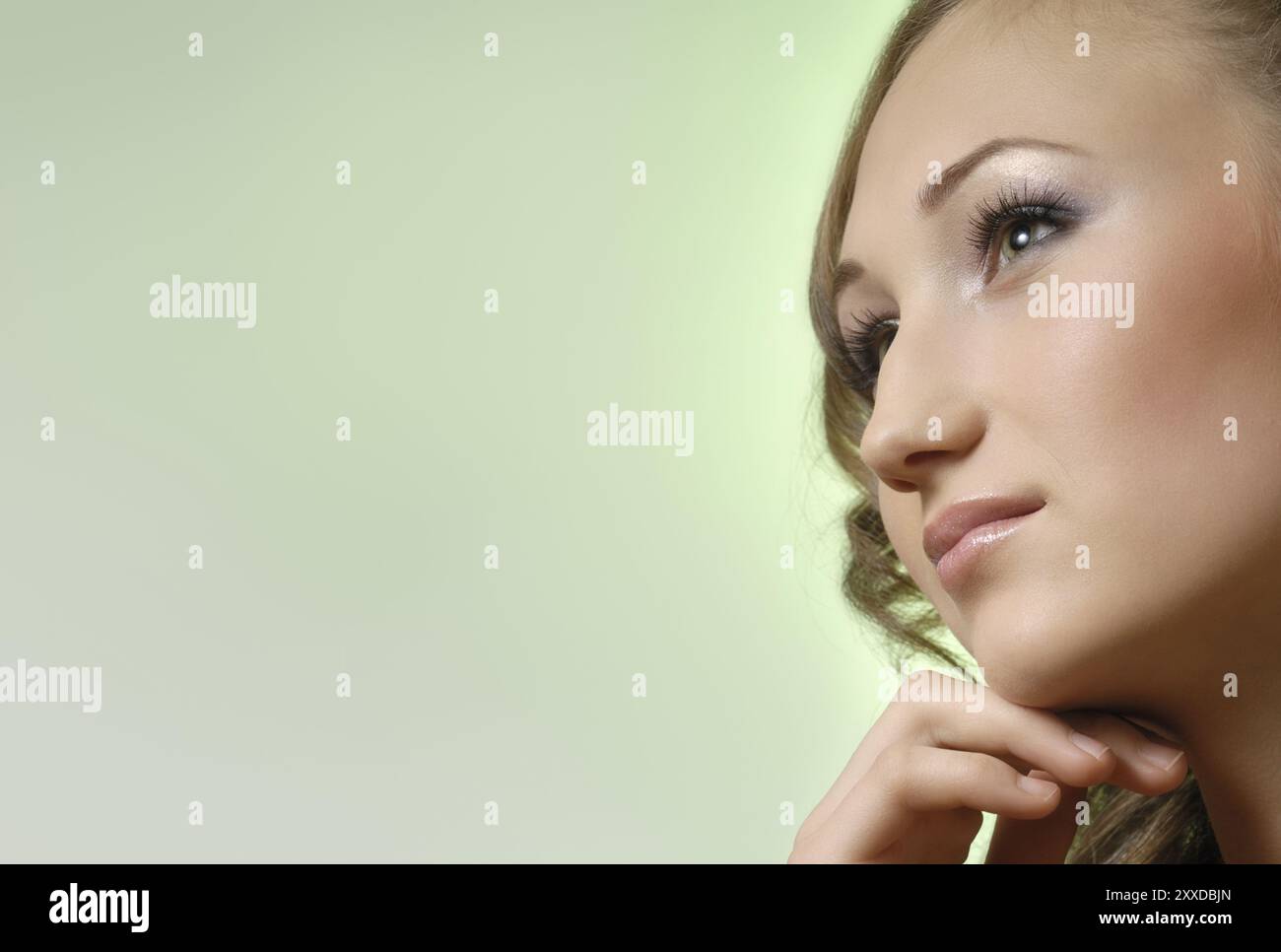 Young woman thoughtful dreamy face profile. Isolated on light green ...