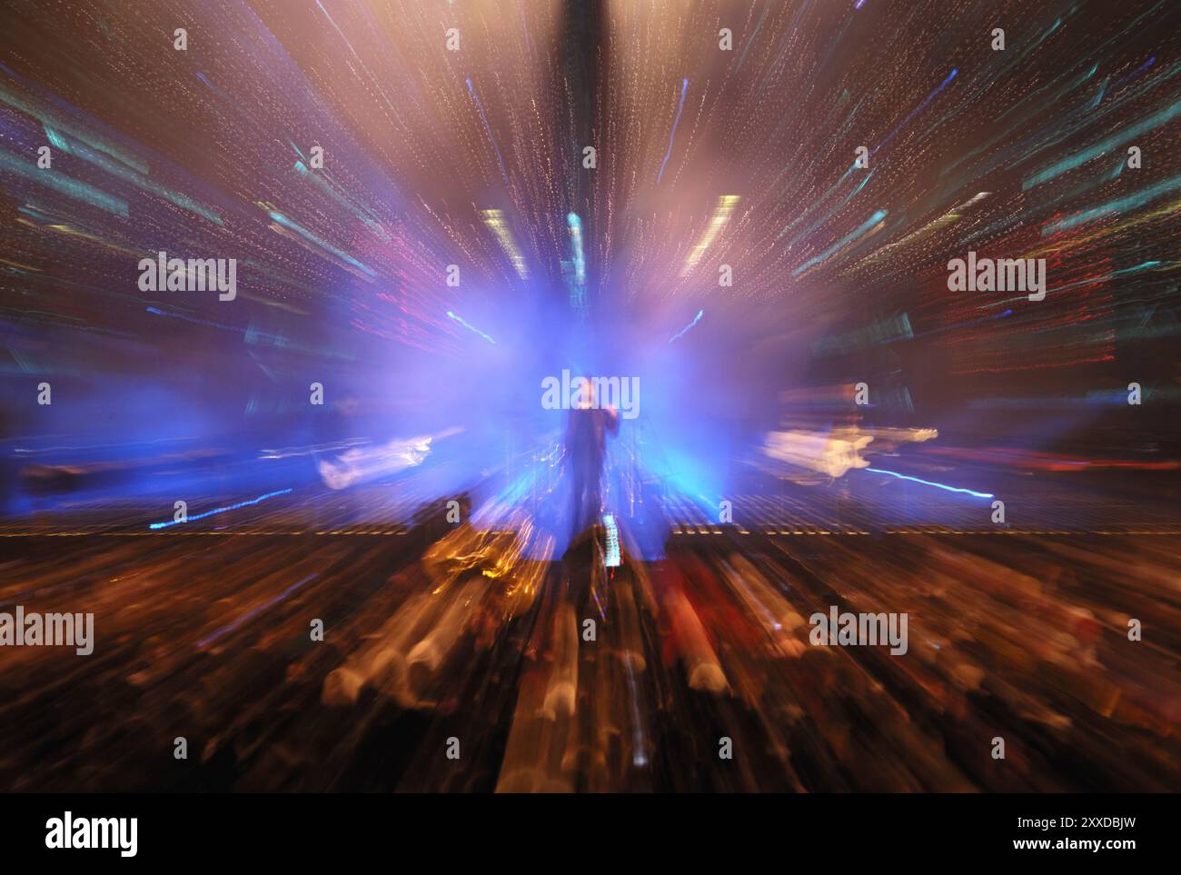 Rock band performing on a stage lit with colorful lights The image has artistic dynamic zoom ...