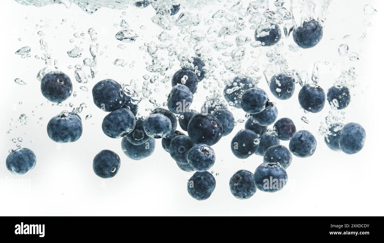 Blueberries sinking into water with air bubbles white background Stock ...