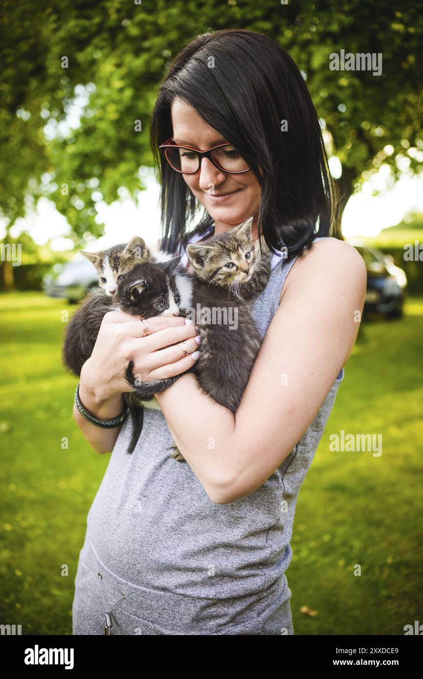 Young woman holding adorable kittens in arms. Pet concept Stock Photo ...