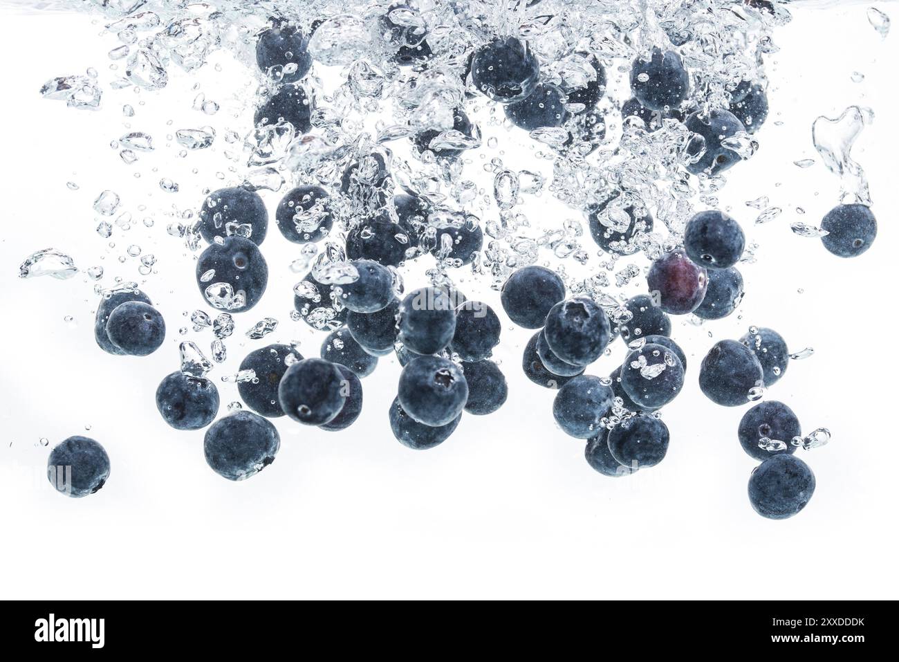 Blueberries sinking into water with air bubbles white background Stock ...