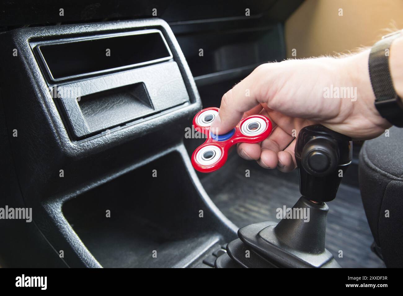 Close-up of a man's hand playing with a spinner while in a traffic jam ...
