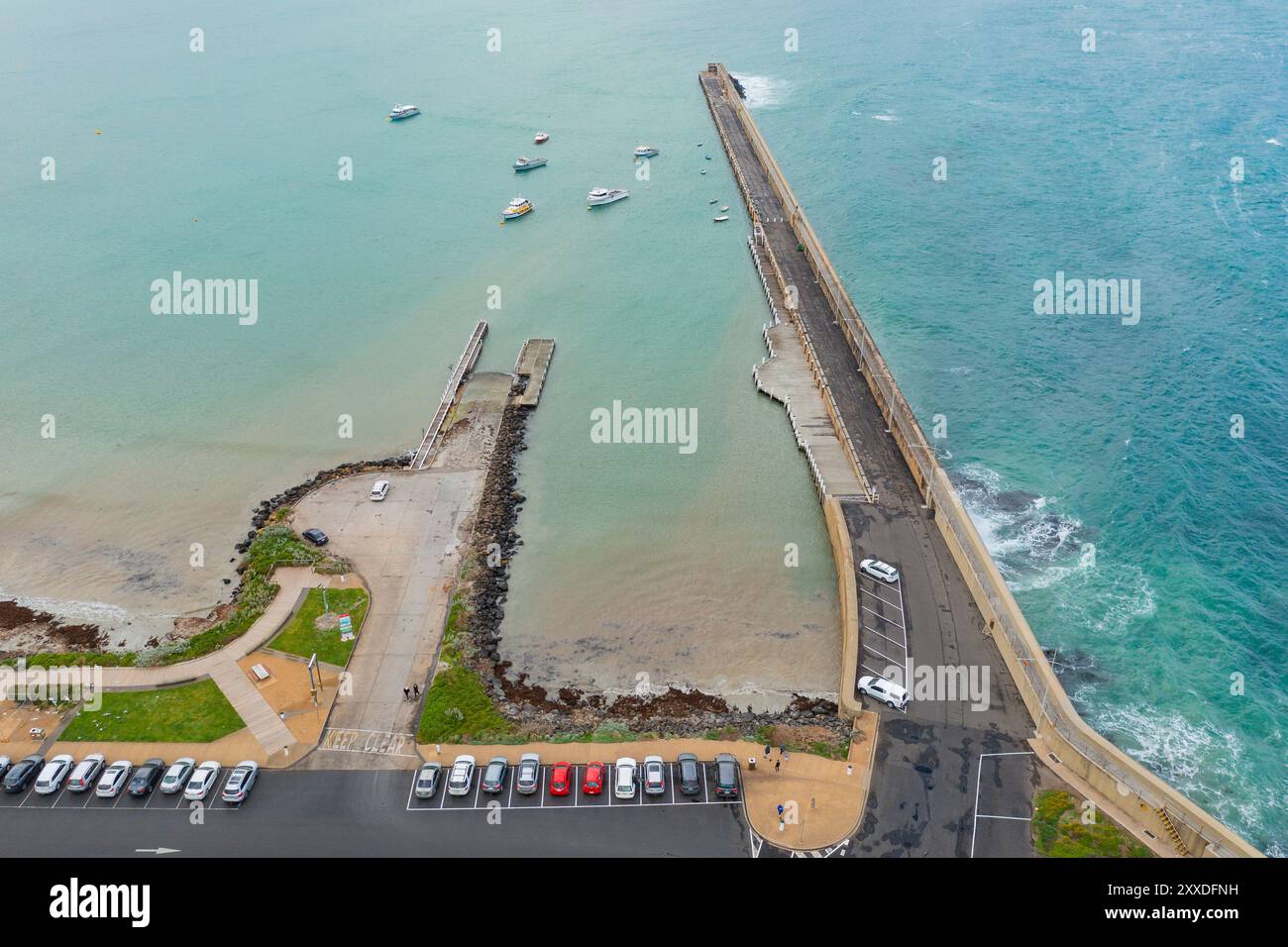 Aerial view of a long narrow breakwater and boat ramp jutting out into ...