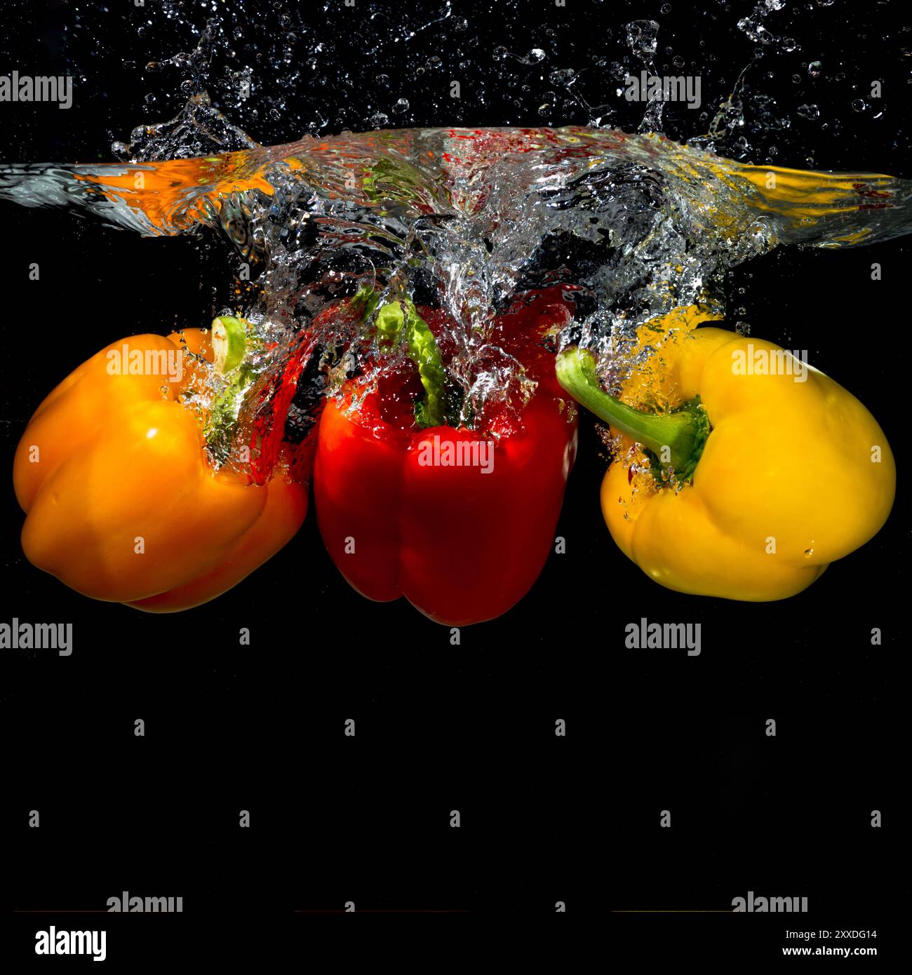 Three bell peppers falling into splash water Stock Photo - Alamy