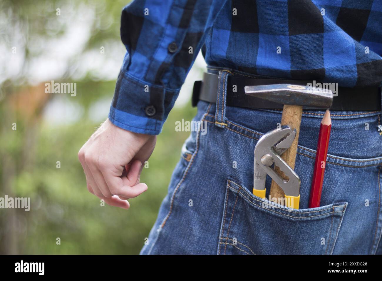 Close up picture of a craftsman with hammer, pencil and gripper in his ...