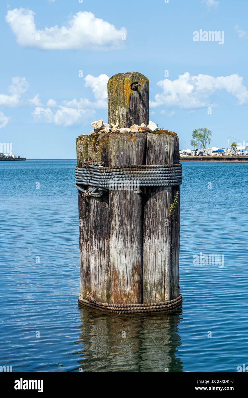 Old wooden mooring post for ships to tie up to located in the harbour ...