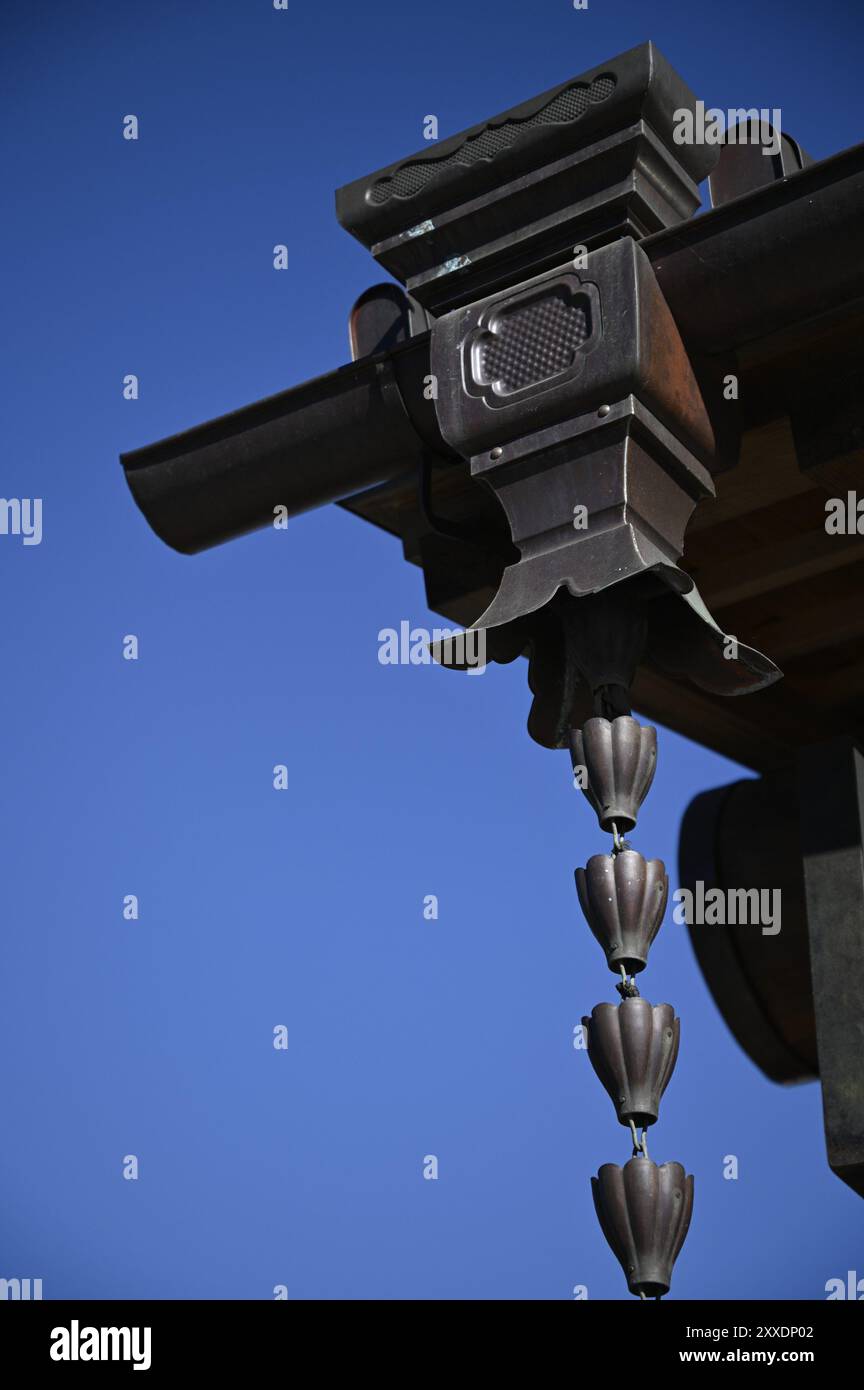 Antique handcrafted Kusari-doi rain chain gutter on the rooftop of a ...