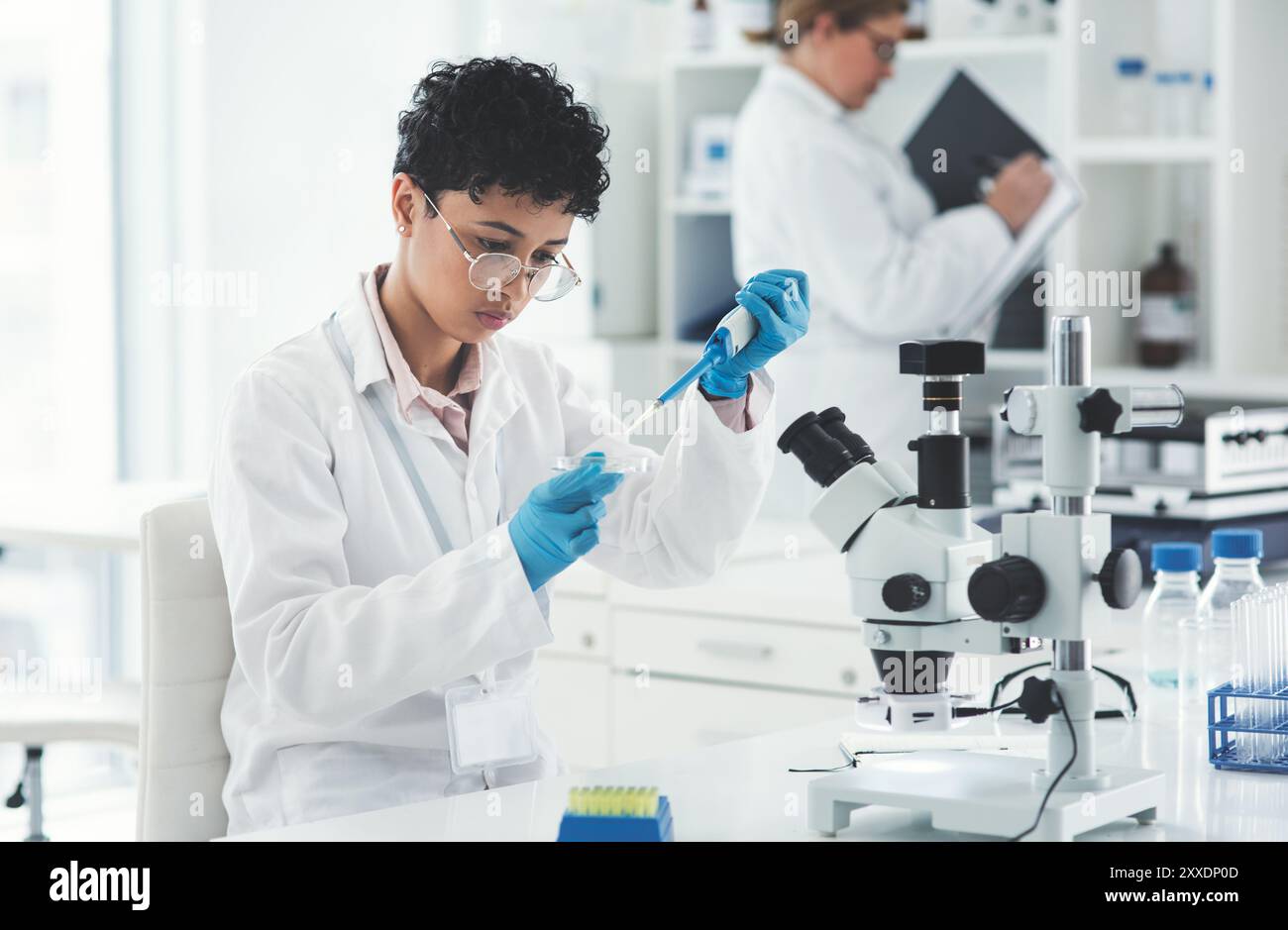 Woman, scientist and liquid with sample in lab for microscope, chemical ...