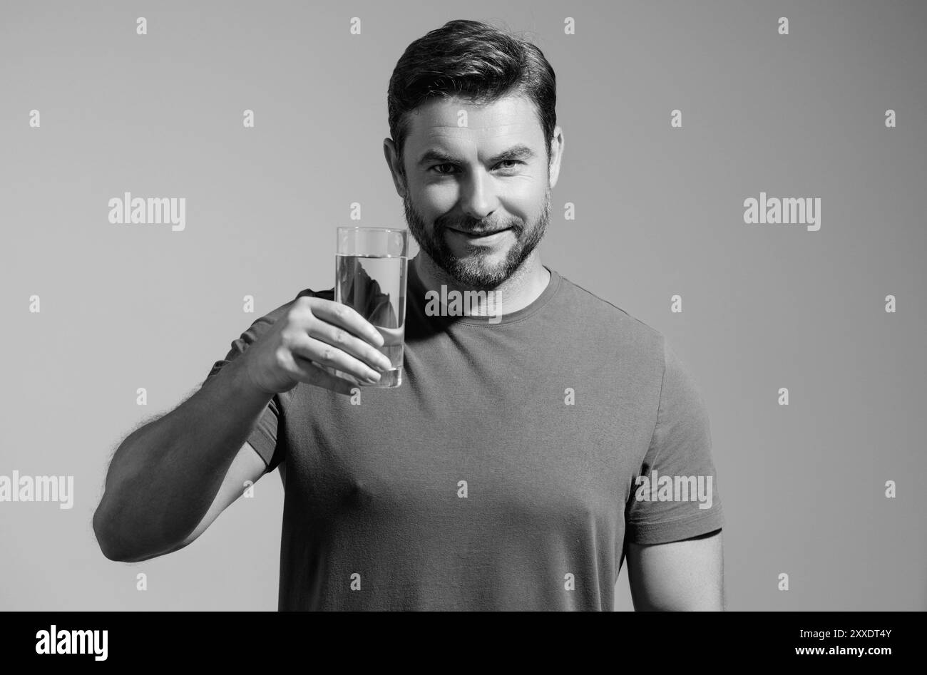 Man drinking fresh water. Male model holds glass of clear water ...