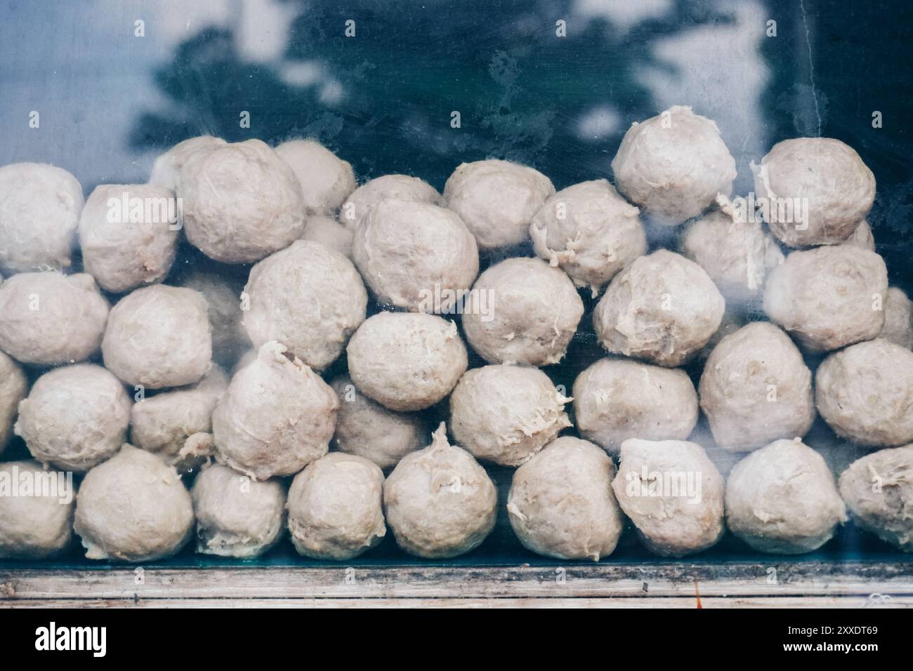 A pile of white meatballs stacked on top of each other. The balls are ...