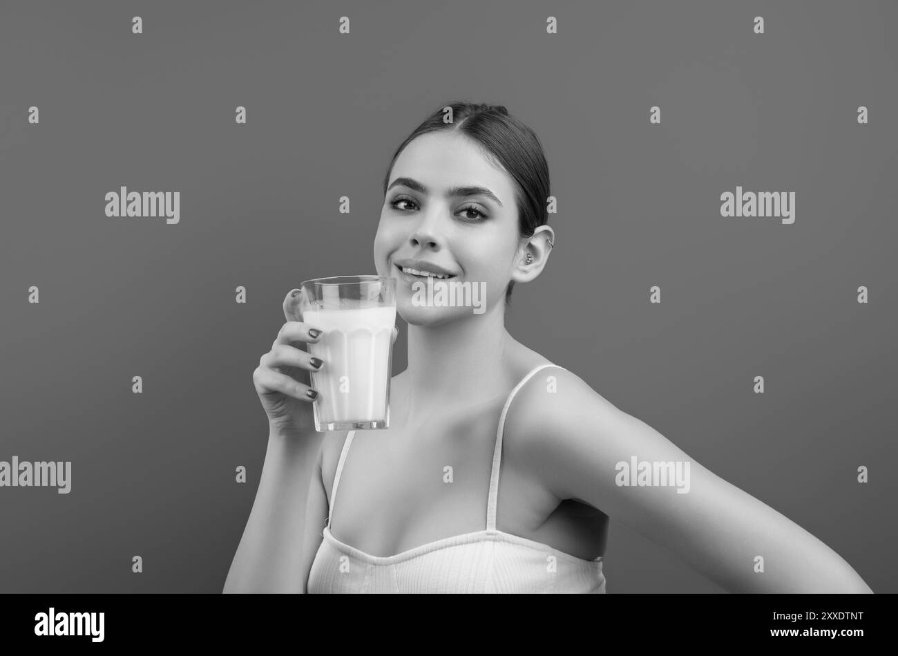 Young woman enjoy pure fresh milk. Thirsty woman hold glass milk ...