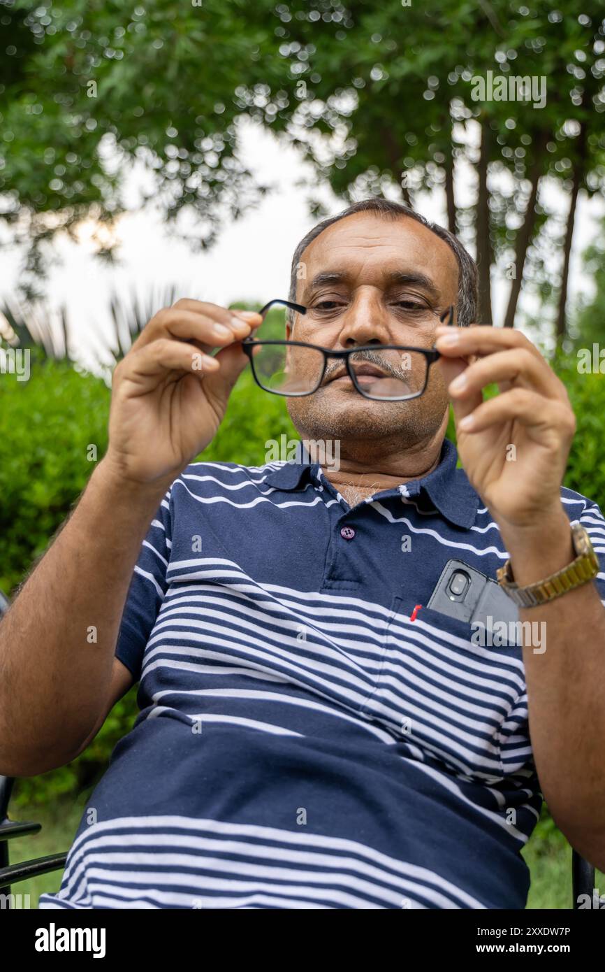 isolated man cleaning his glasses at outdoor park at evening from flat angle Stock Photo - Alamy