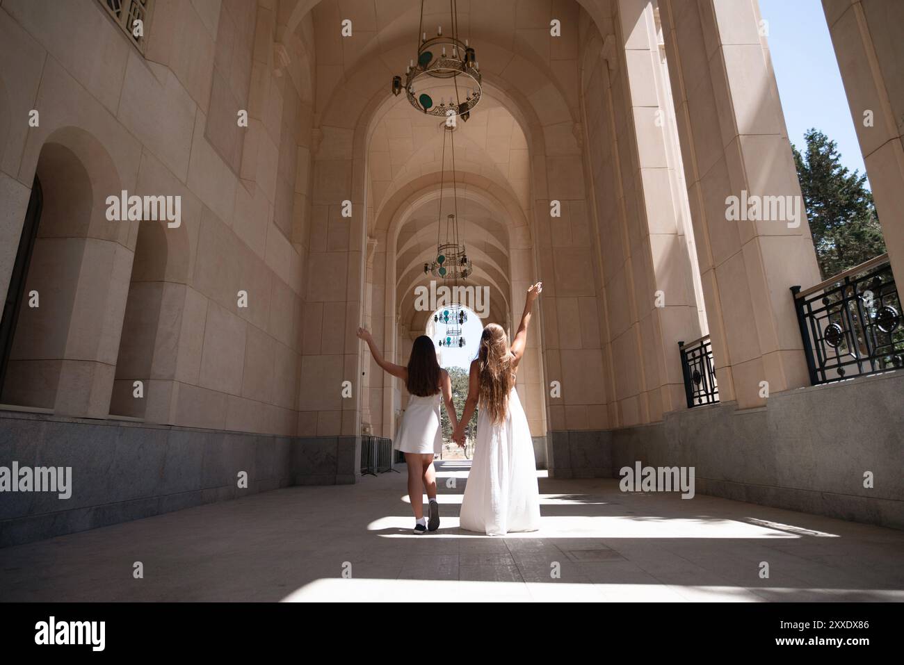 Women White Dresses Arches Two women wearing white dresses pose in an ...