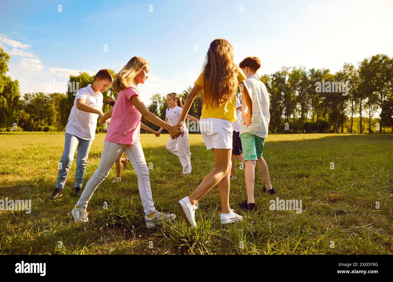 Group of a kids friends playing outside in the park standing in a ...