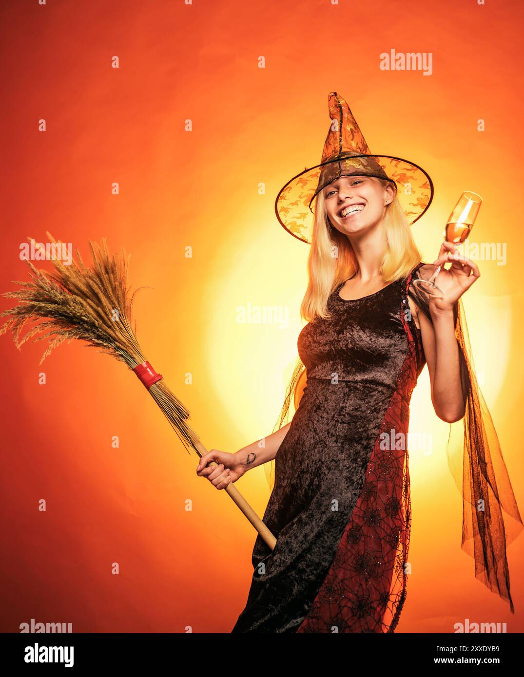 Beautiful young surprised woman in witches hat and costume pointing ...