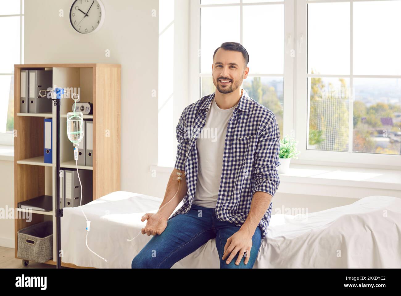 Young happy man receiving IV drip infusion and vitamin therapy in ...