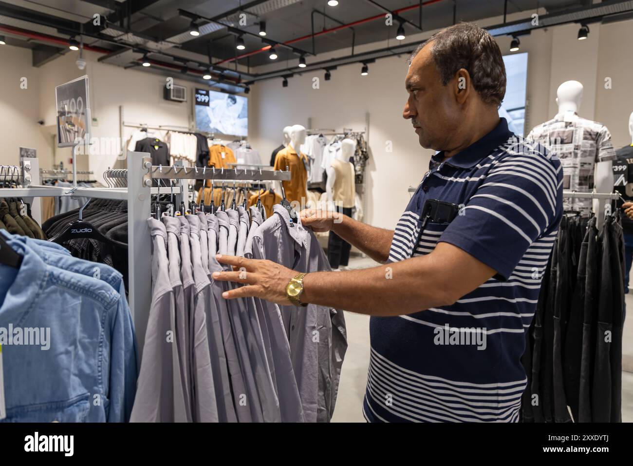 Man Selecting Clothes at Indoor Shopping Mall Stock Photo - Alamy