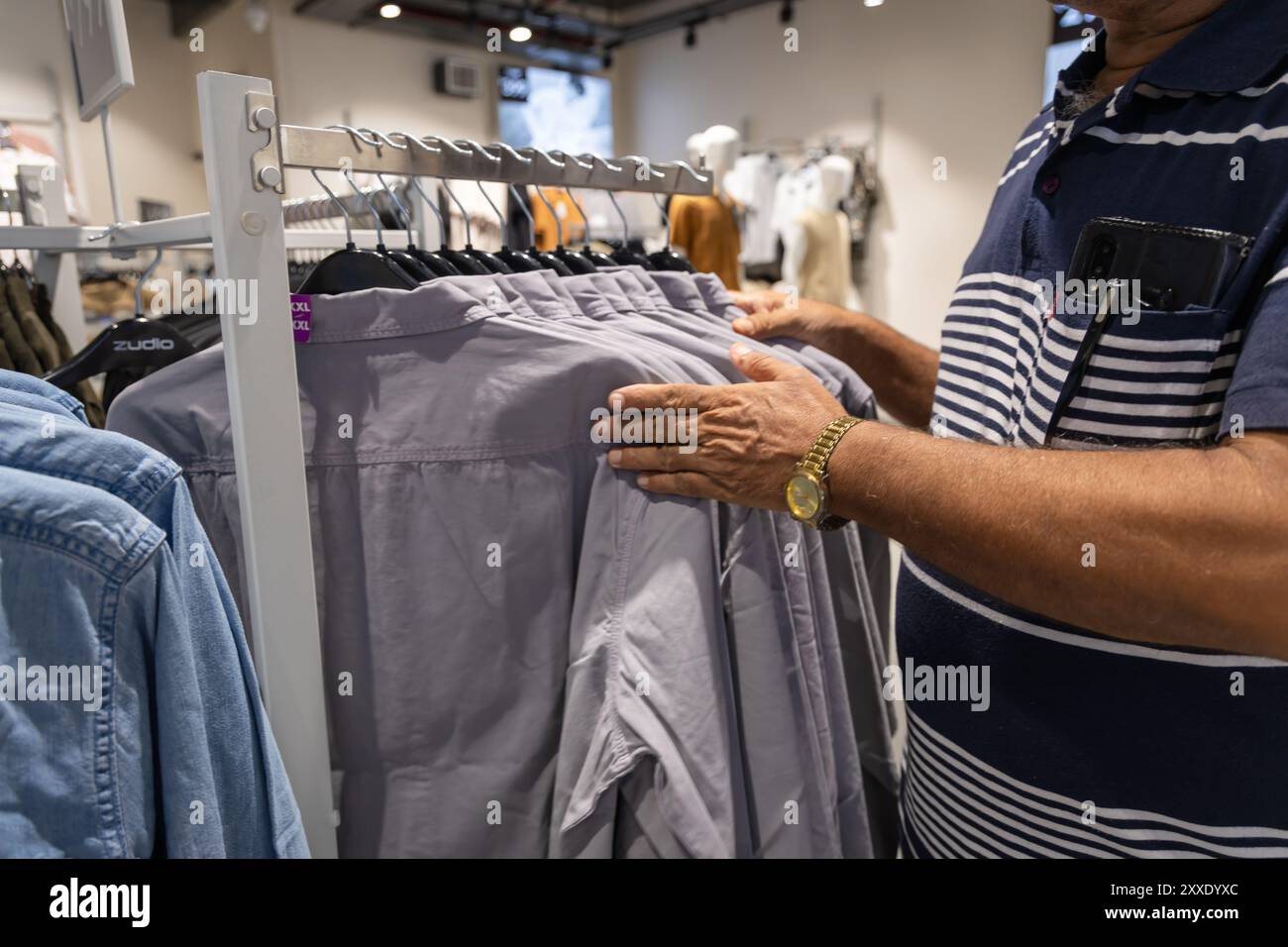 Man Selecting Clothes at Indoor Shopping Mall Stock Photo - Alamy